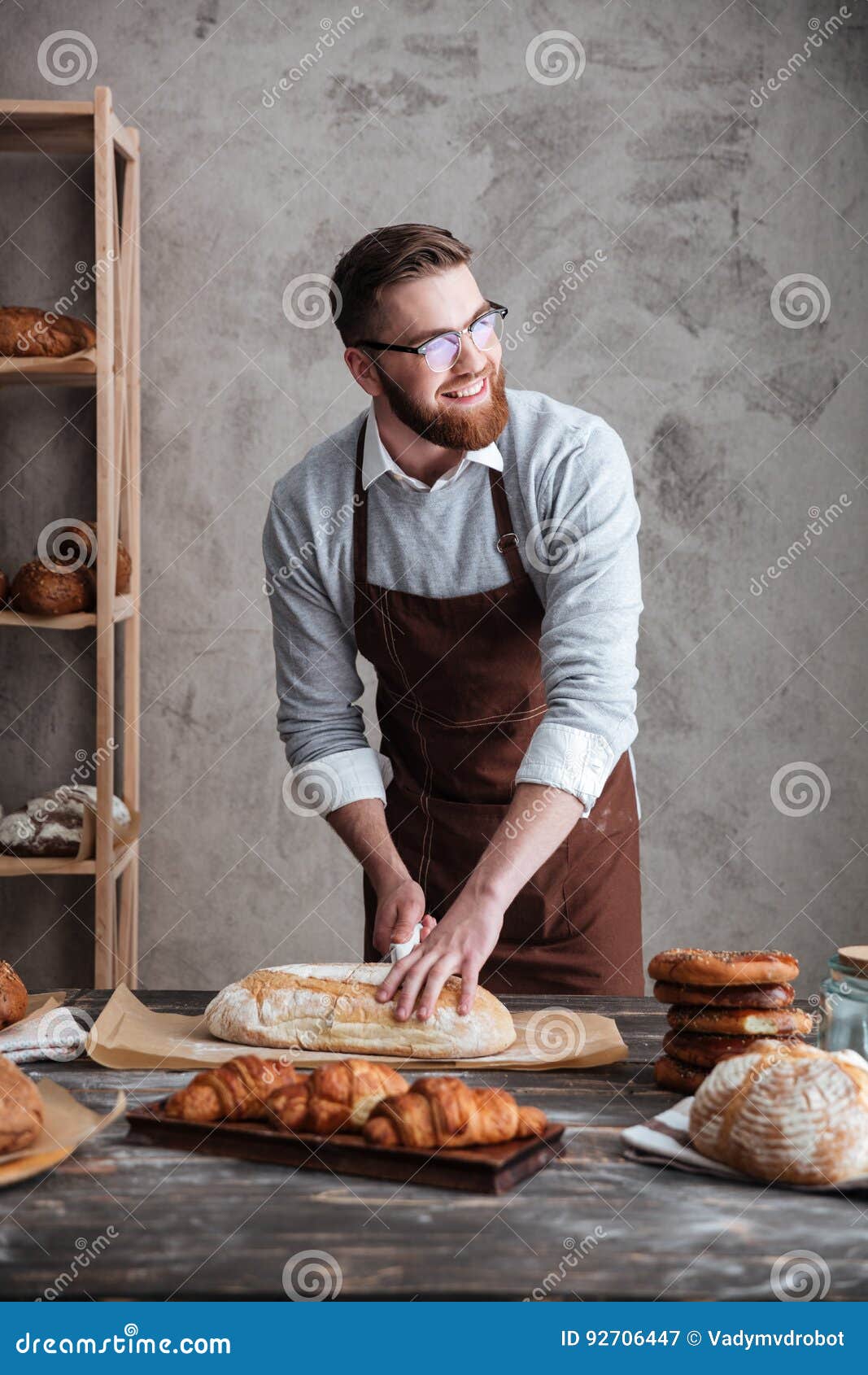Happy Young Man Baker Standing at Bakery Cut the Bread. Stock Image ...