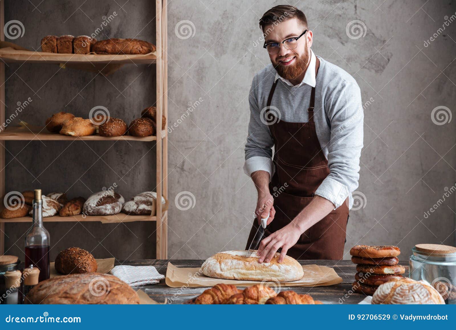 Happy Young Man Baker Standing at Bakery Cut the Bread Stock Image ...