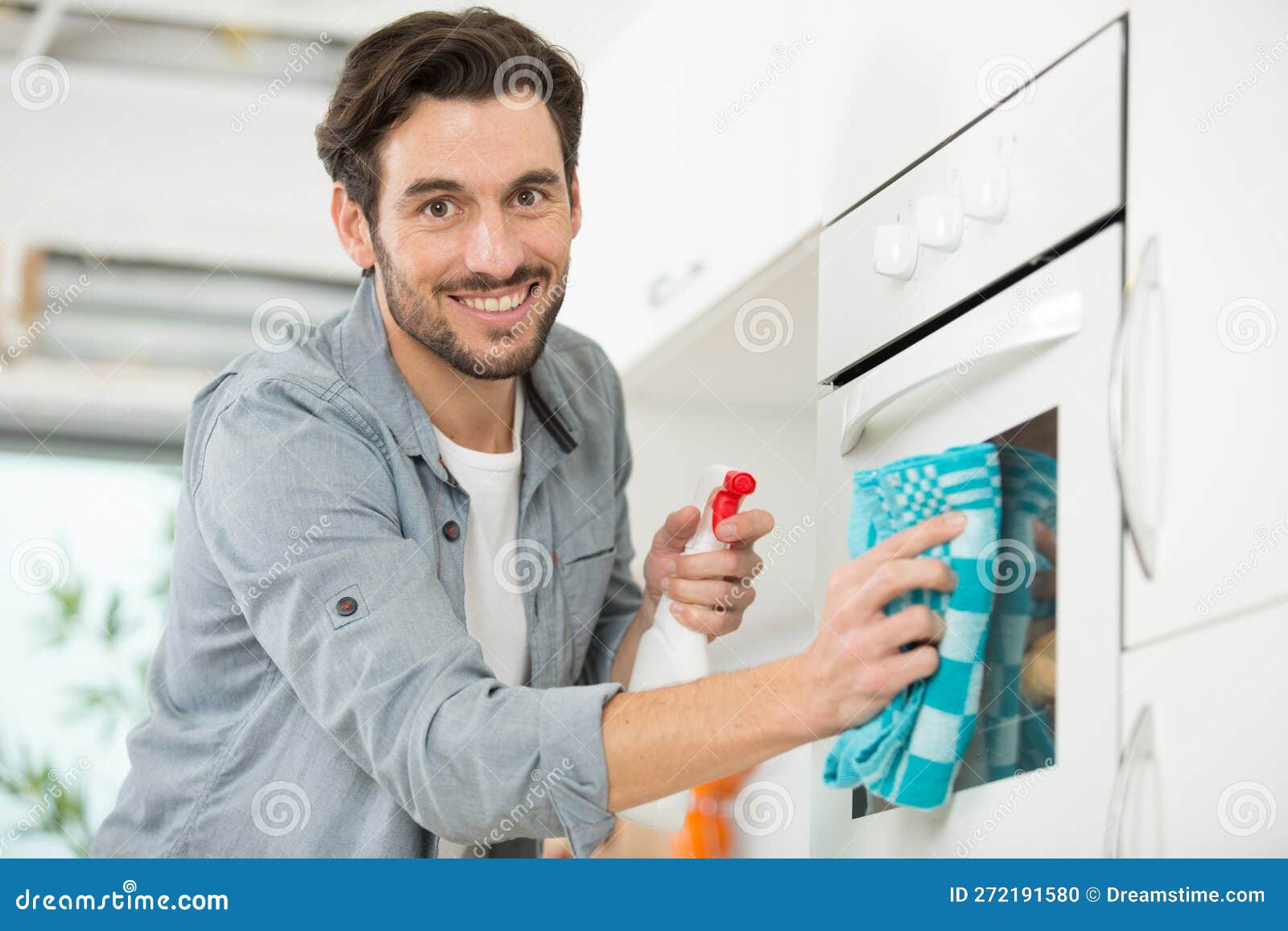 Happy Young Man Cleaning Oven with Rag and Bottle Spray Stock Photo ...