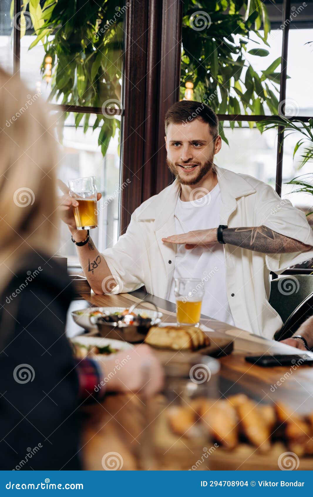 Happy Young Man Drinking Draft Beer while Having Fun in Pub or Bar with ...