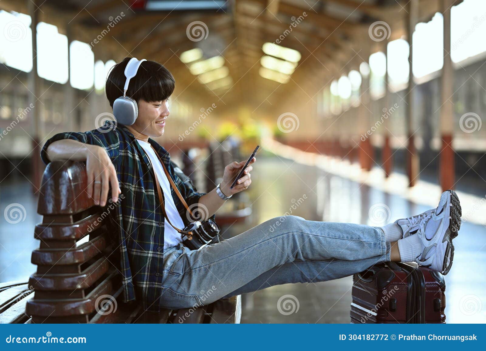 Happy Young Man in Headphone Using Mobile Phone during Waiting for ...