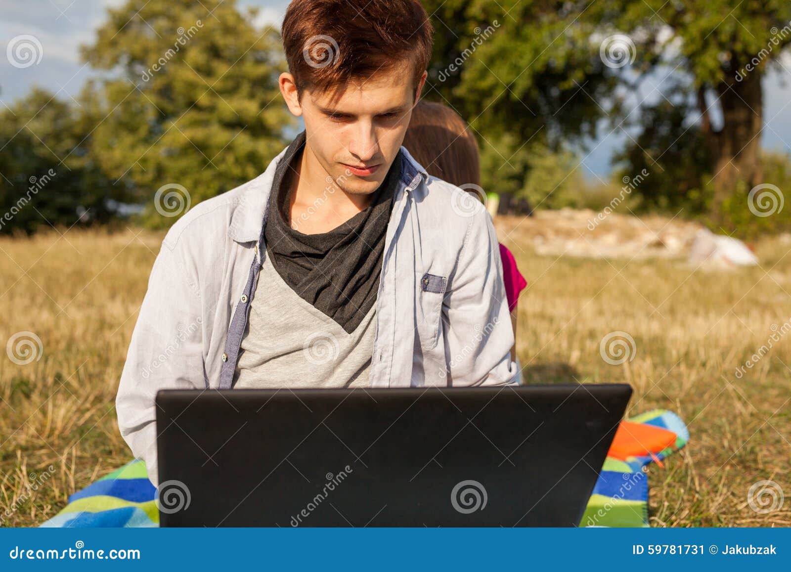 Happy Young Man in Park Writing Article on His Laptop. Stock Image ...