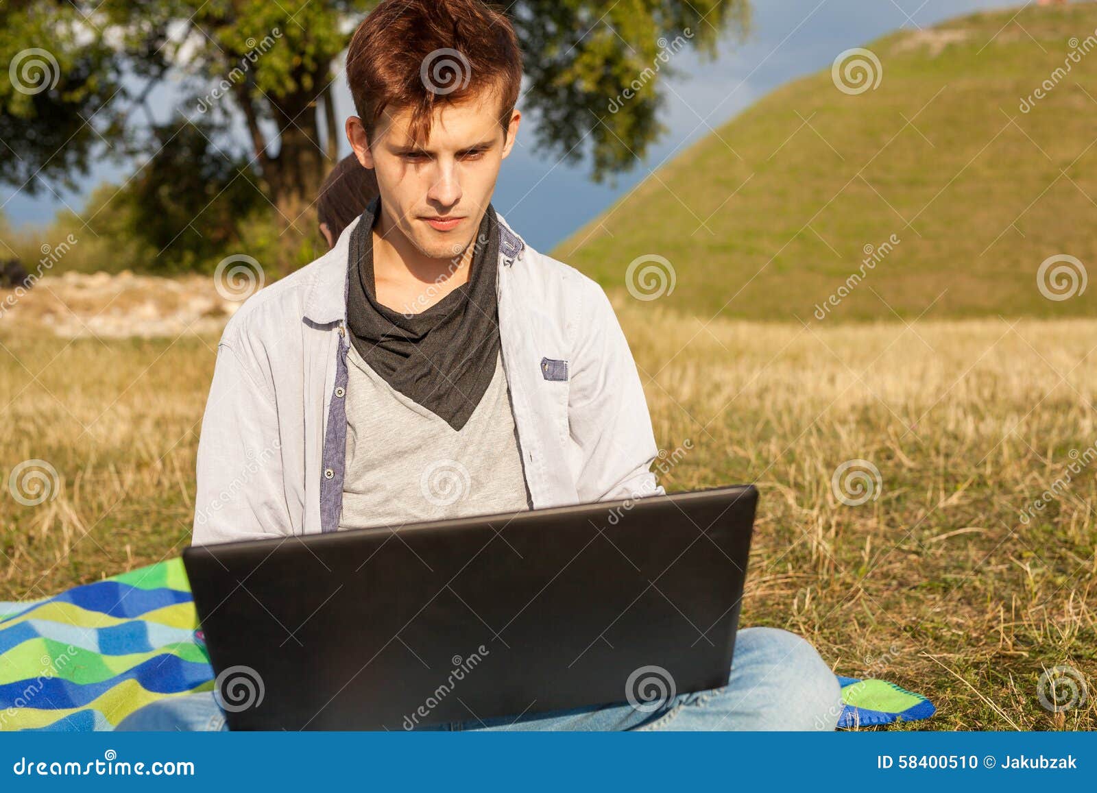 Happy Young Man in Park Writing Article on His Laptop. Stock Photo ...