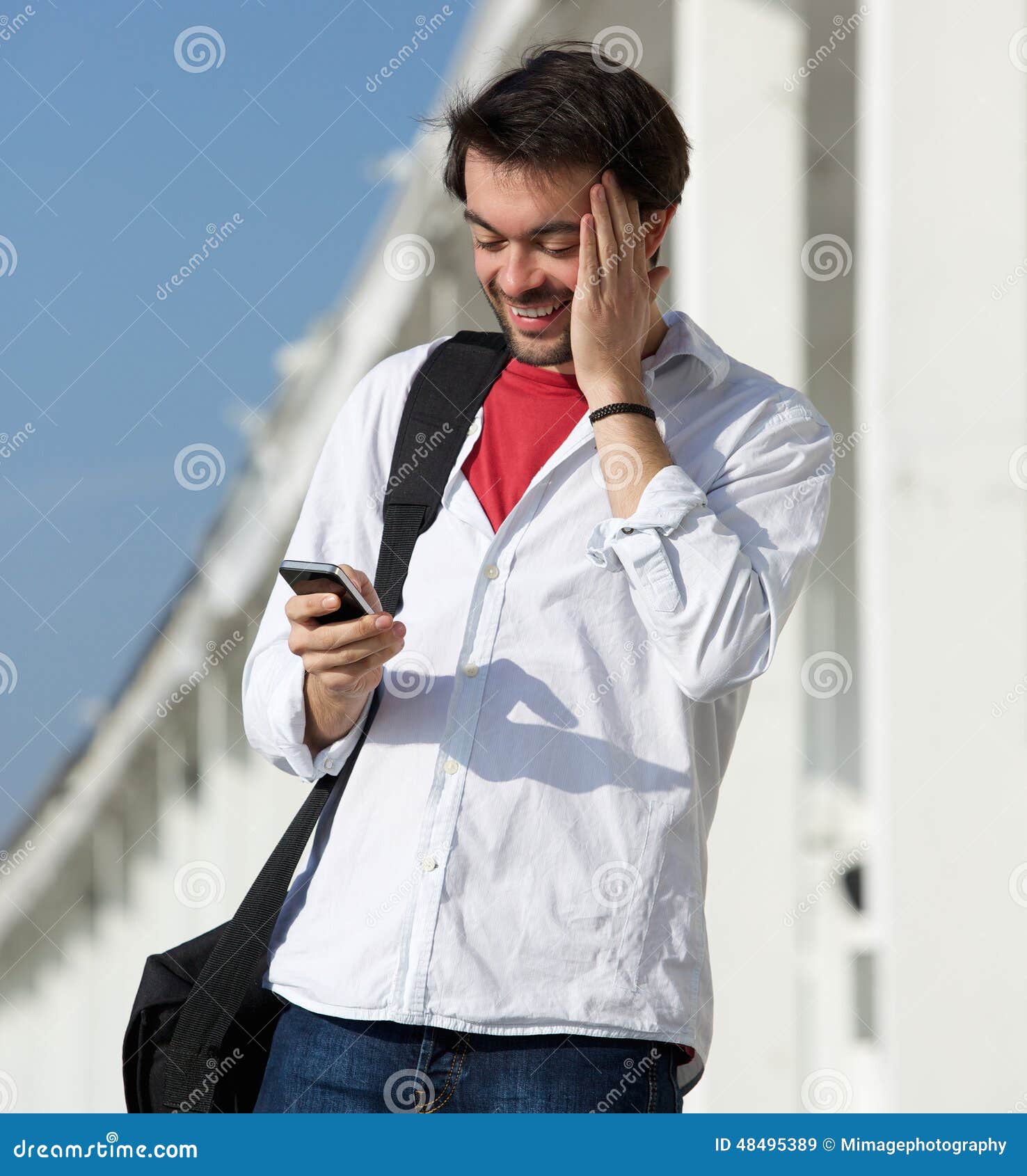 Happy Young Man Reading Text Message on Cell Phone Stock Image - Image ...
