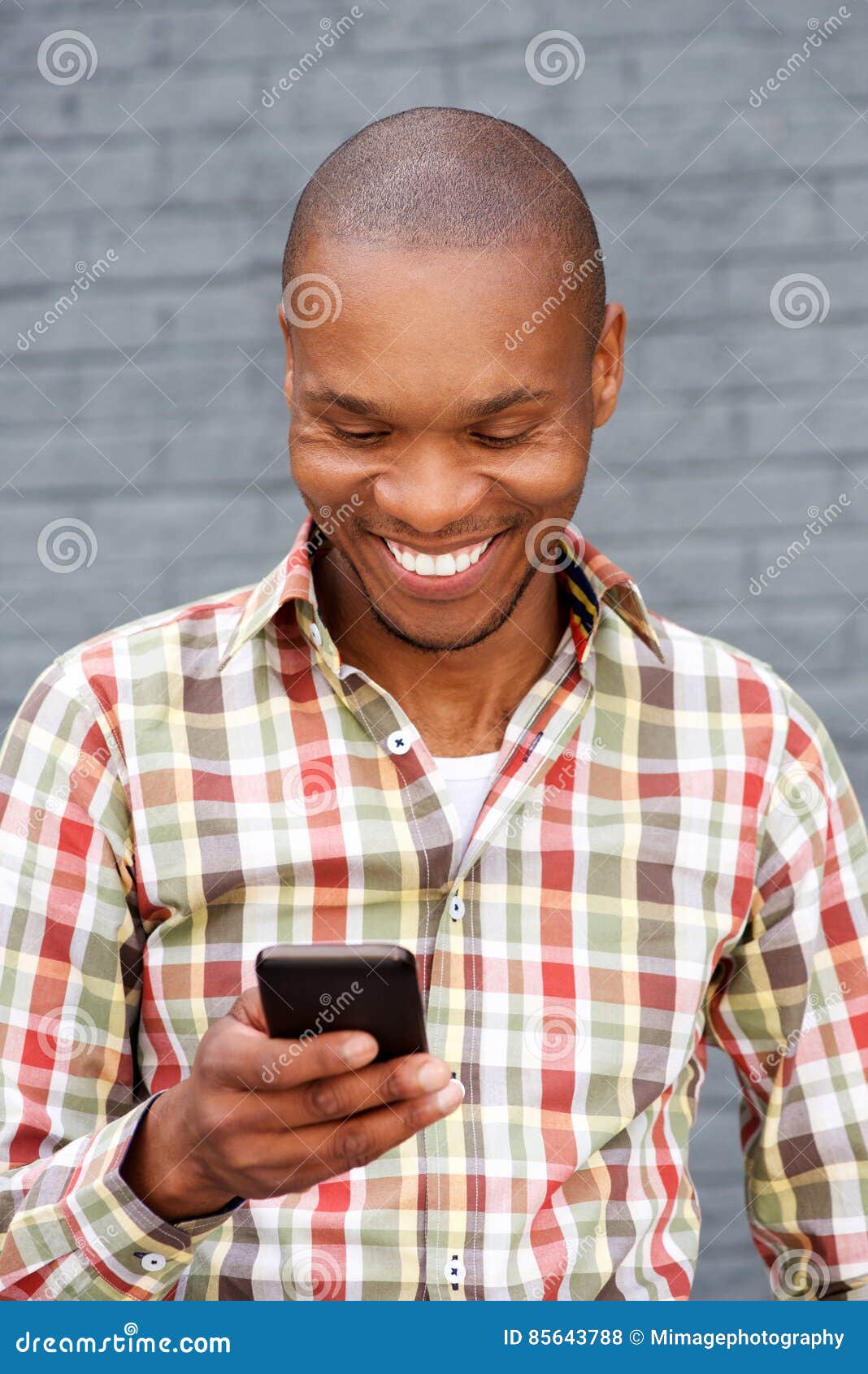 Happy Young Man Reading Text Message on Mobile Phone Stock Photo ...