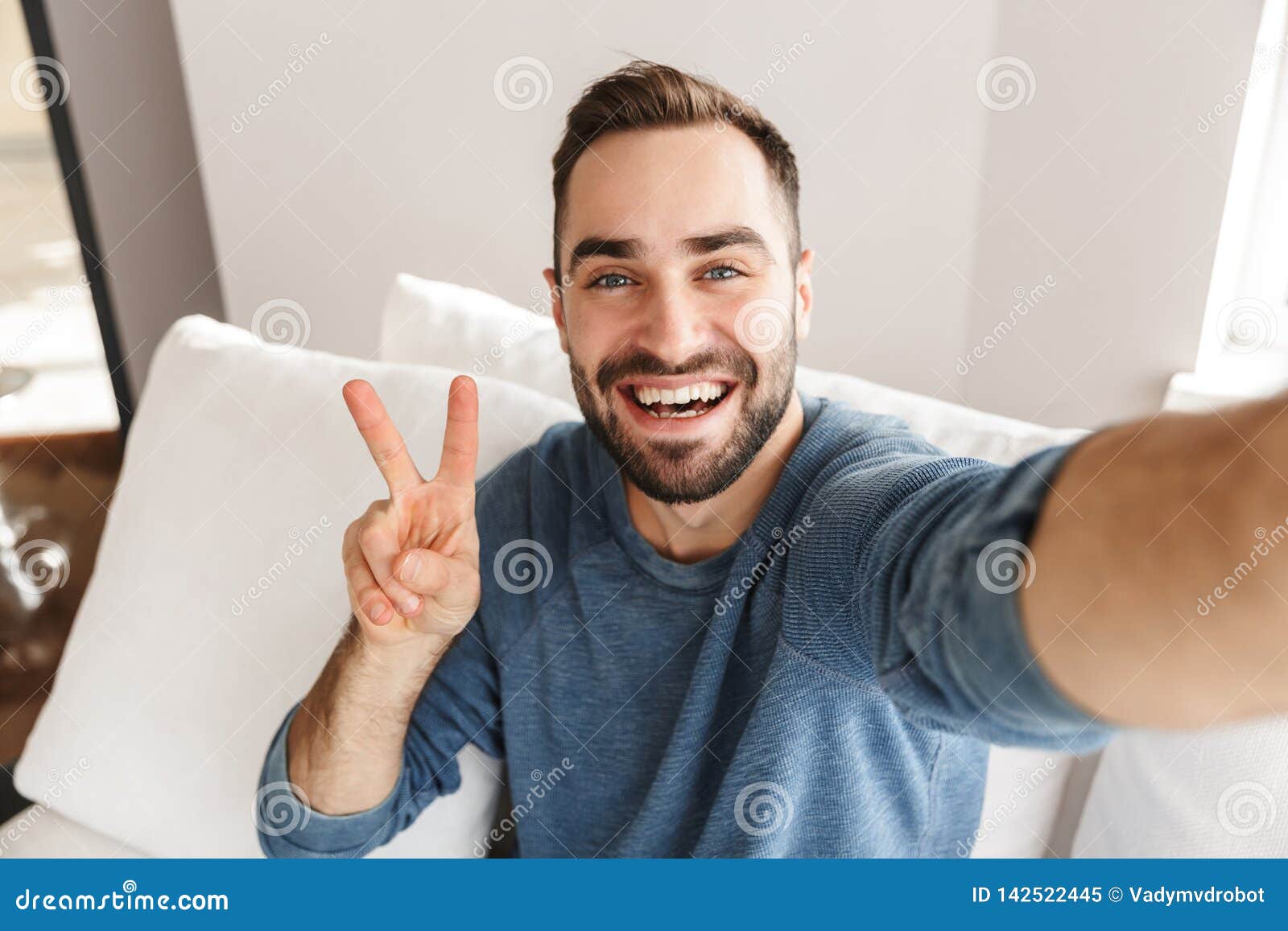 Happy Young Man Sitting on a Couch at Home Stock Image - Image of ...
