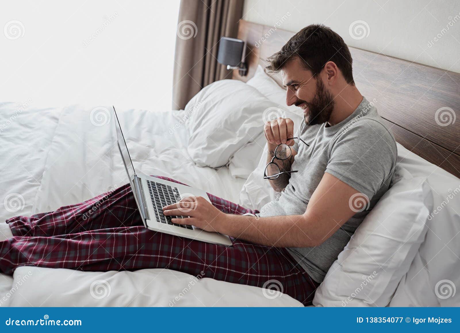 Happy Man Using Laptop Computer while Sitting in Bed Stock Image ...