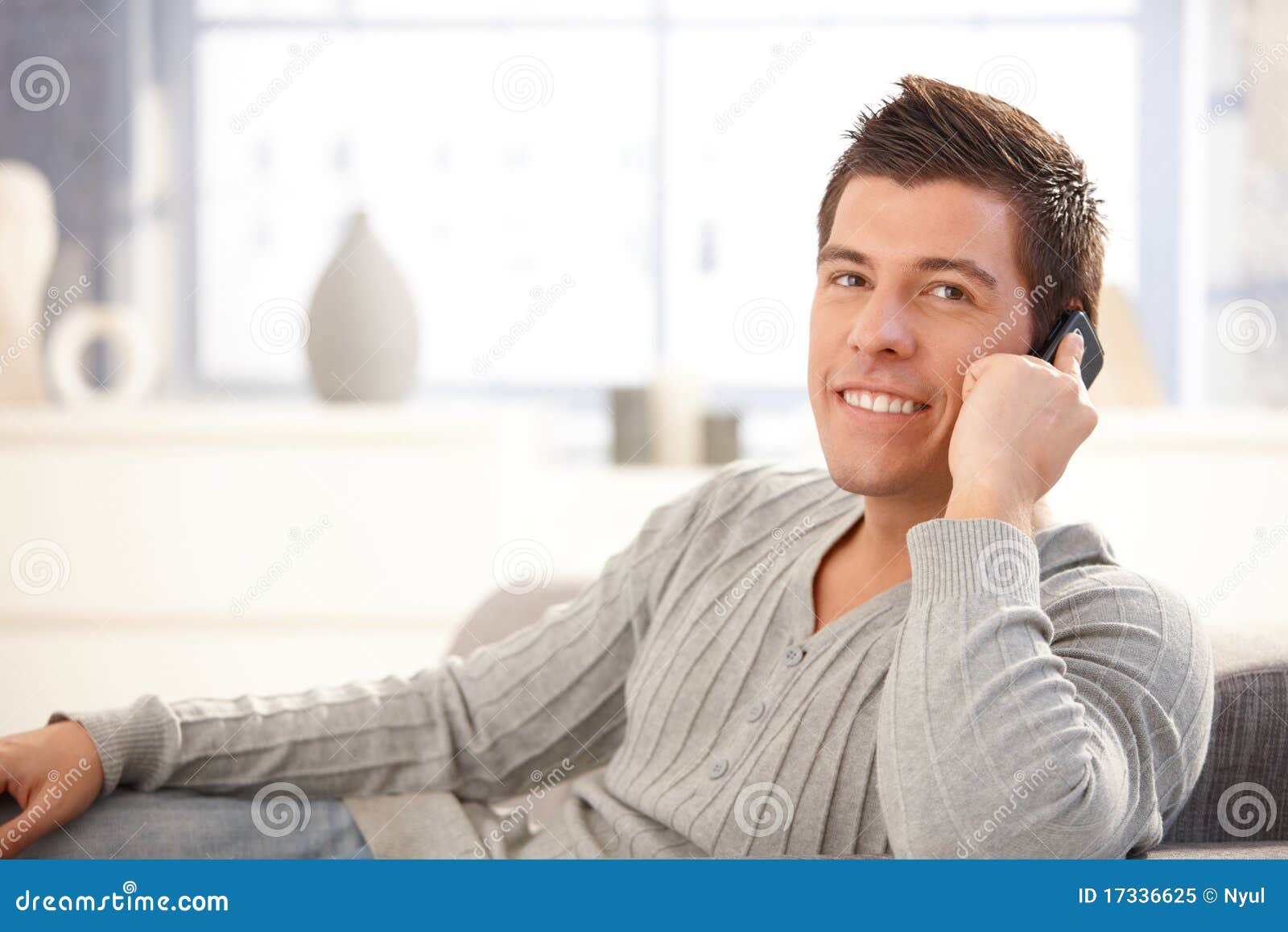 Happy Young Man Using Mobile Phone Stock Image - Image of indoors ...