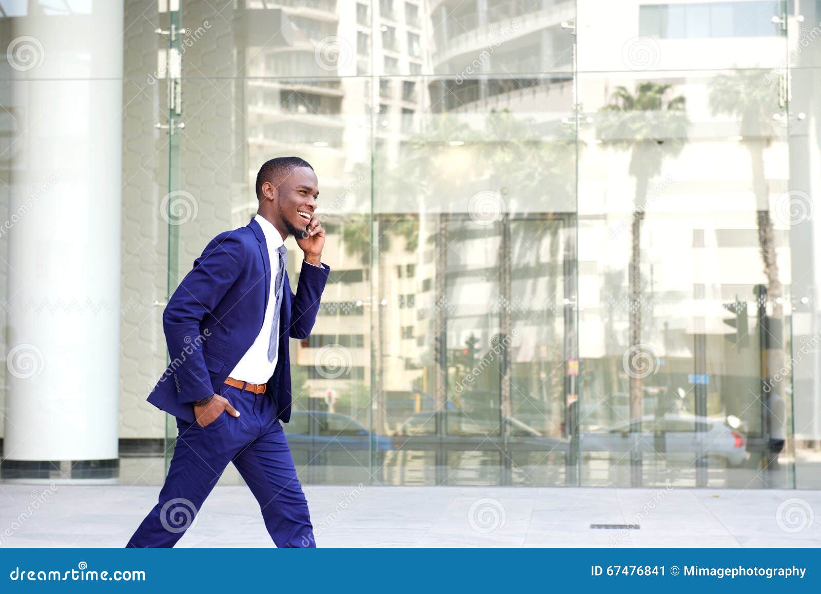Happy Young Man Walking and Talking on Mobile Phone Stock Image - Image ...