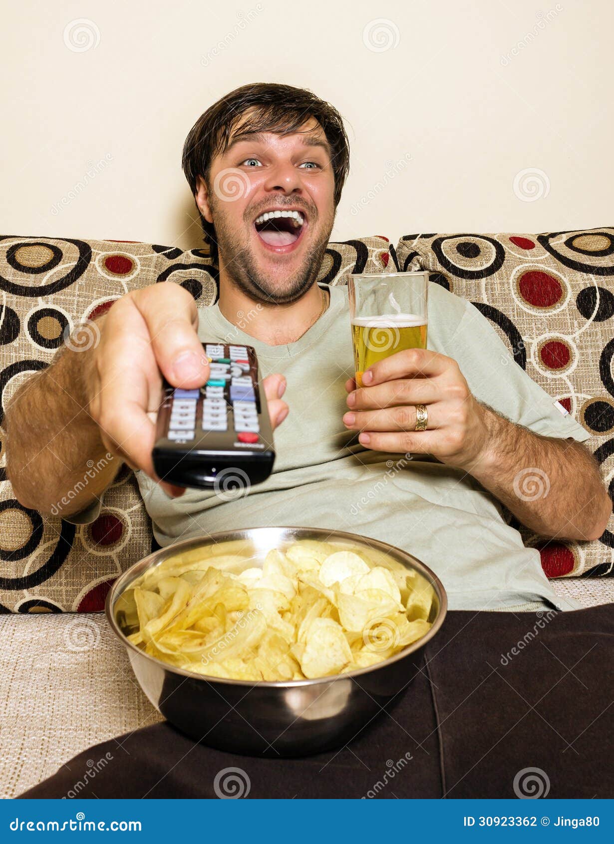 Happy Young Man Watching Television, Eating Potato Chips and Drinking ...