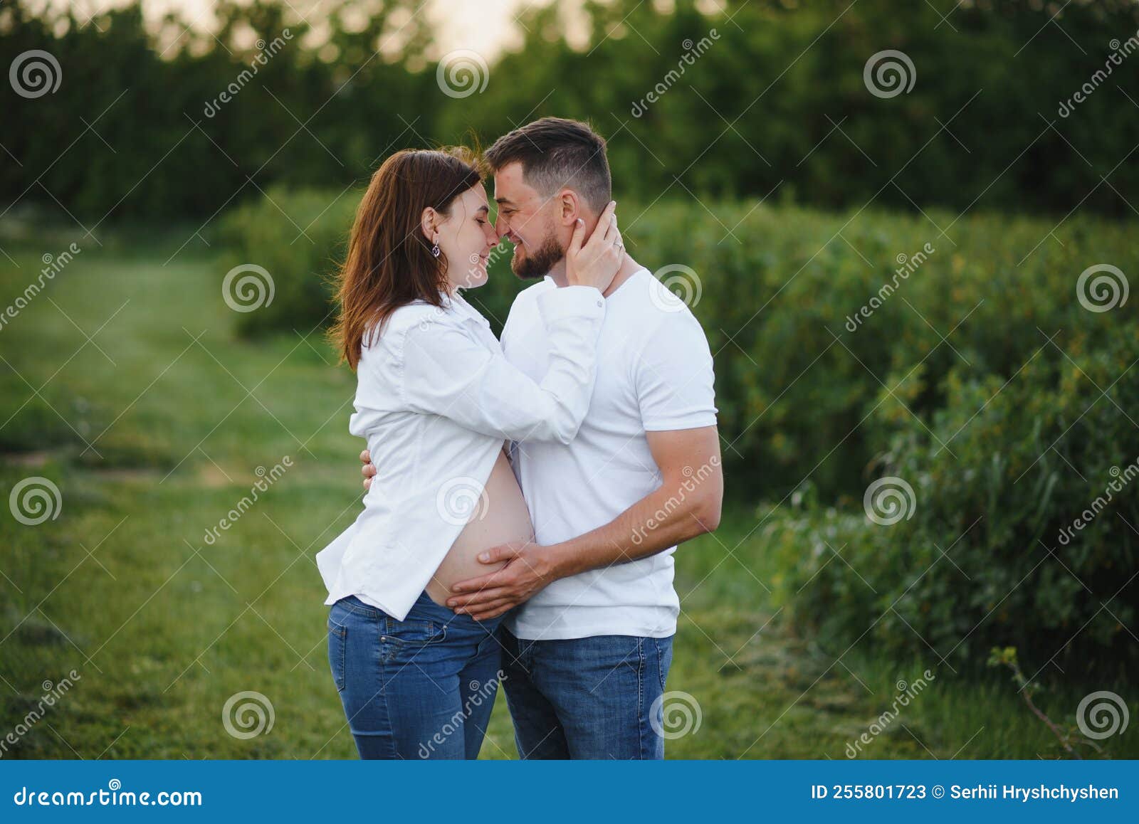 Happy And Young Pregnant Couple Hugging In Nature Stock Image Image