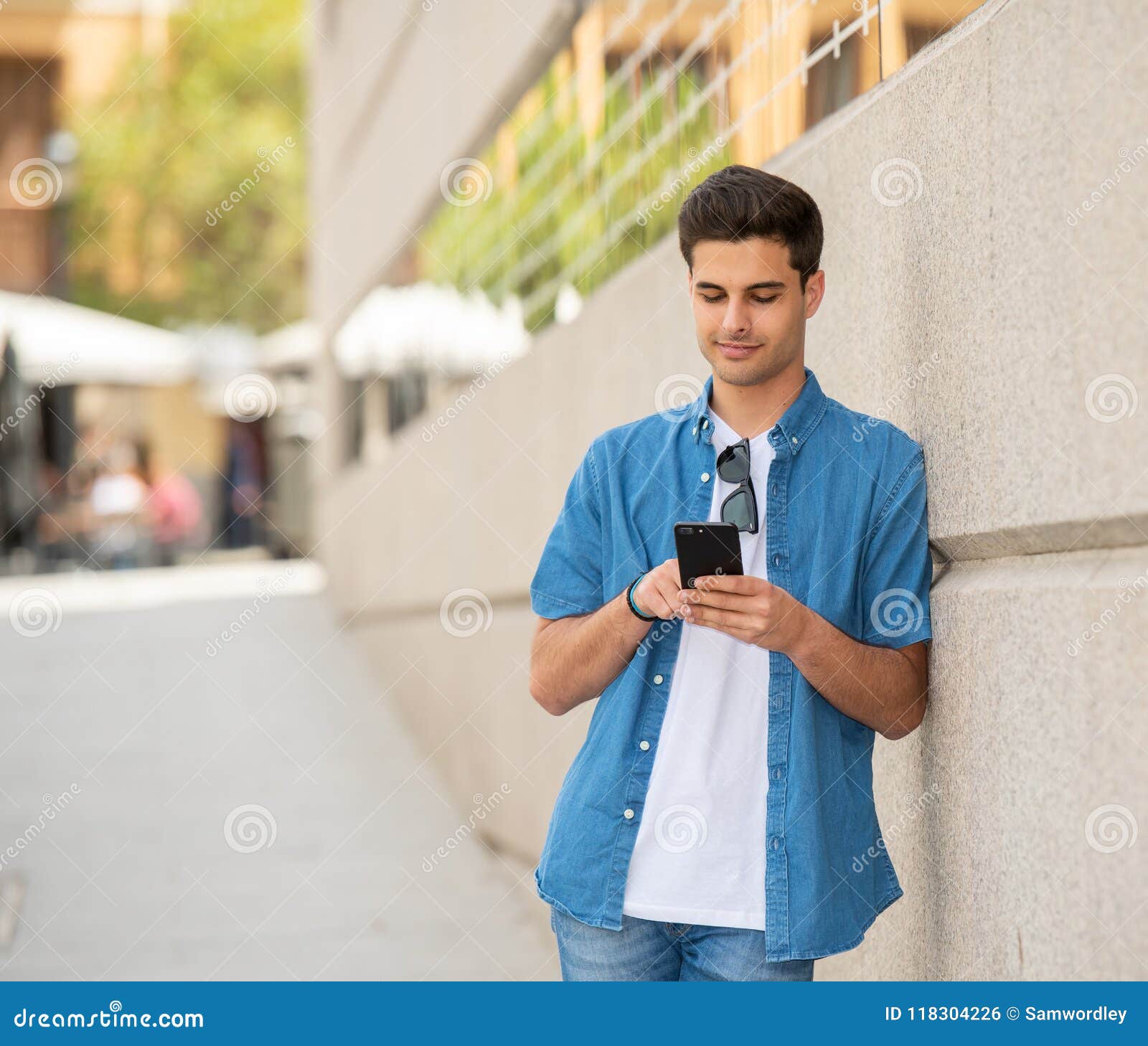 Happy Young Student Male Texting on His Smart Phone in Modern Ci Stock ... Happy Young Student Male Texting on His Smart Phone in Modern Ci Stock ...