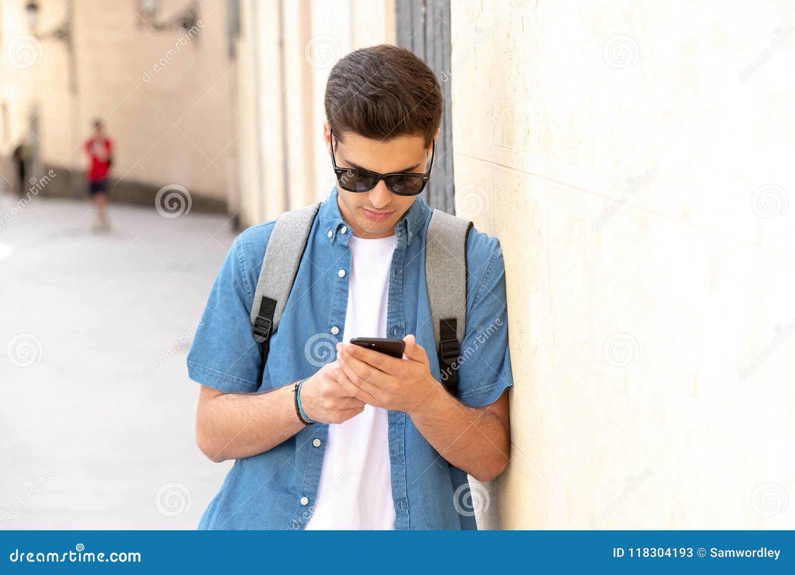 Happy Young Student Male Texting on His Smart Phone in Modern City ... Happy Young Student Male Texting on His Smart Phone in Modern City ...