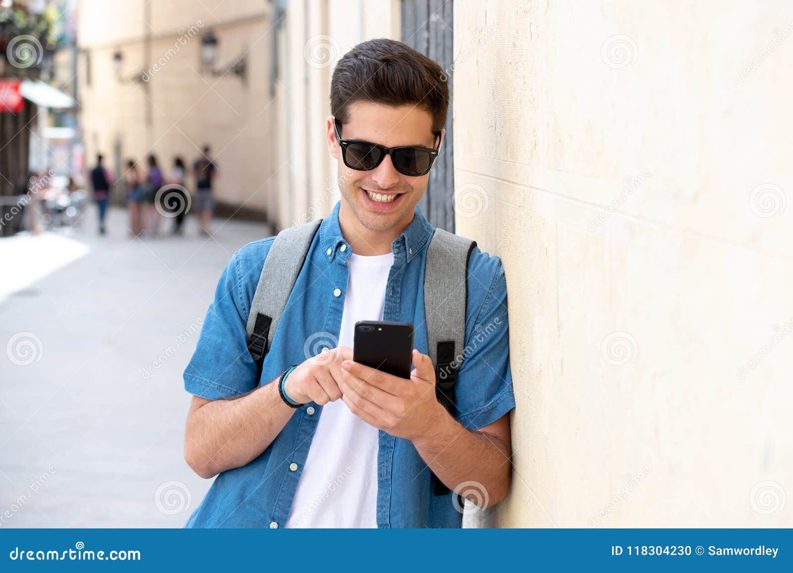 Happy Young Student Male Texting on His Smart Phone in Modern City ... Happy Young Student Male Texting on His Smart Phone in Modern City ...