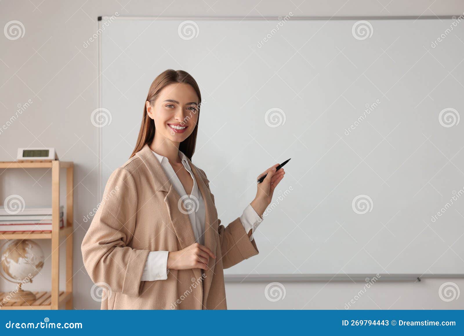 Happy Young Teacher Explaining Something at Whiteboard in Classroom ...
