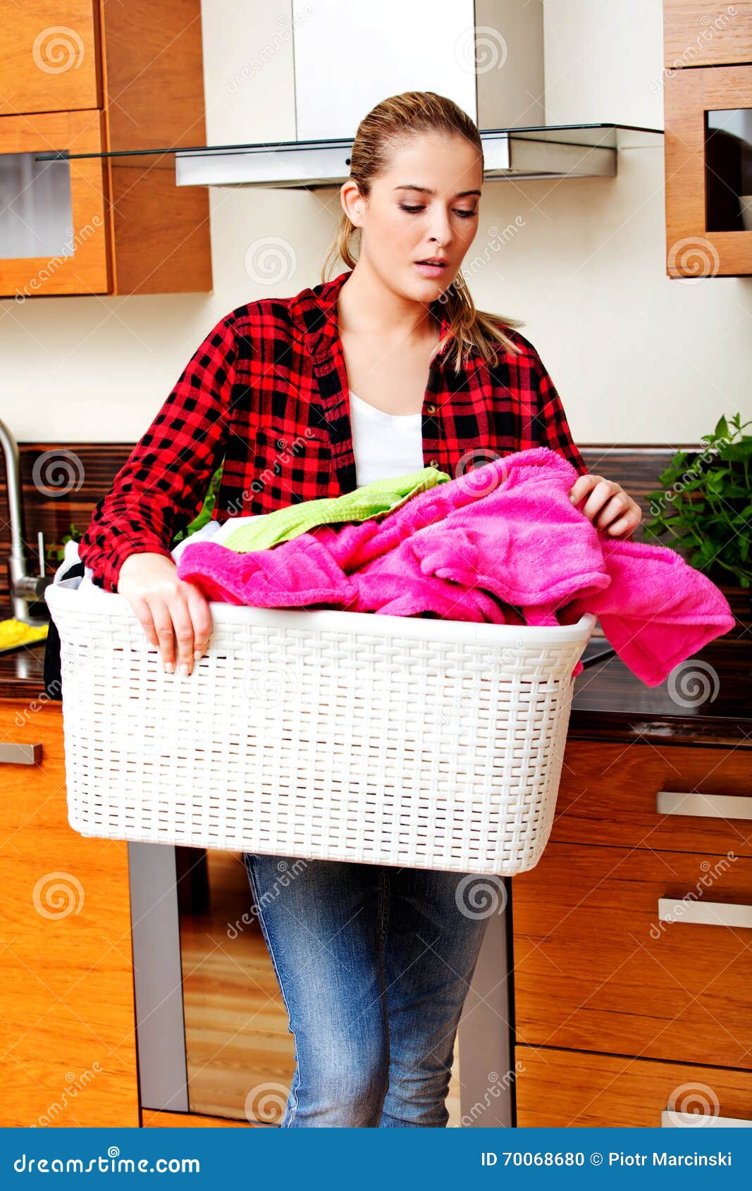 Happy Young Woman Carrying Laundry Basket in Kitchen Stock Photo ...