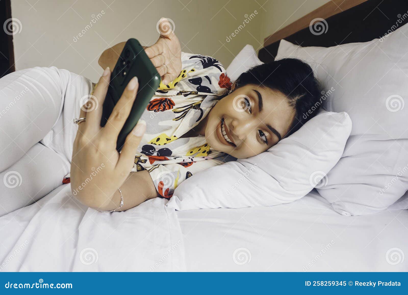 Happy Young Woman Checking on Her Phone while Lying in Bed Stock Image ...