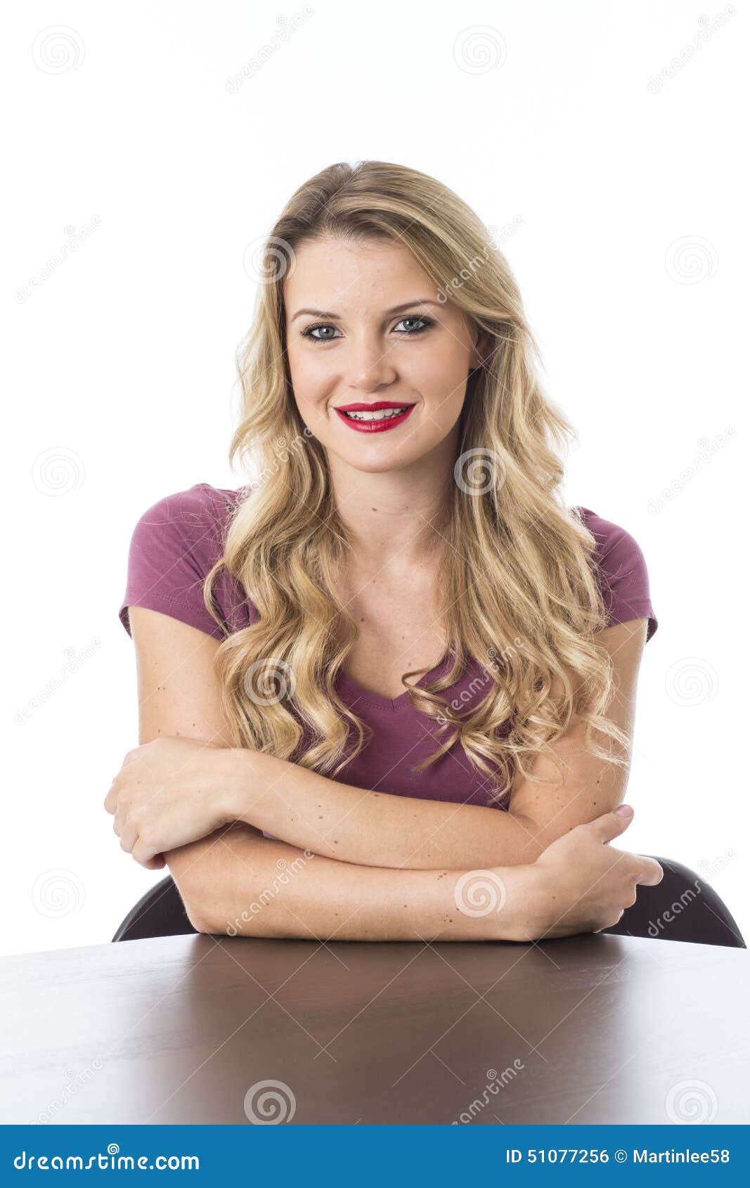 Happy Young Woman Sitting at a Table with Arms Folded Stock Photo ...
