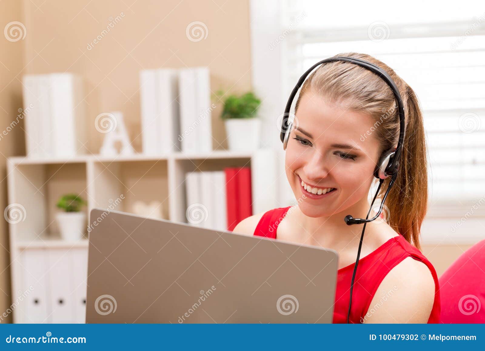 Happy Young Woman Using Her Laptop and Headset Stock Photo - Image of ...