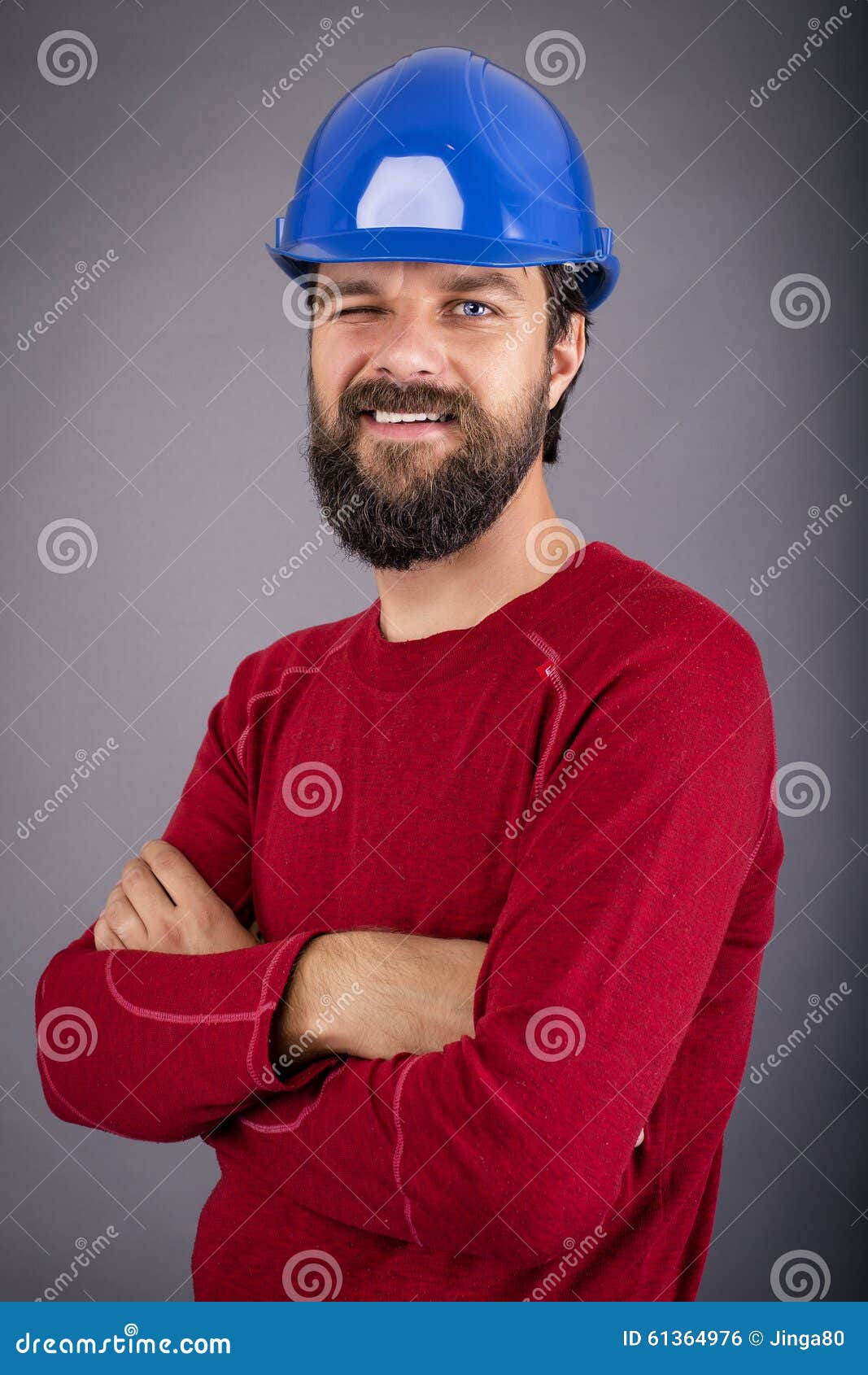 Happy Young Worker with Hardhat and Arms Folded Blinking Stock Photo ...