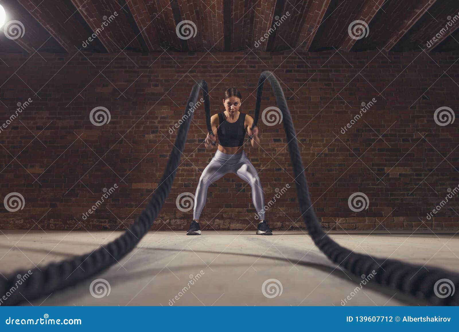 Young Caucasian Woman Working Out with Battle Ropes at a Gym Stock ...