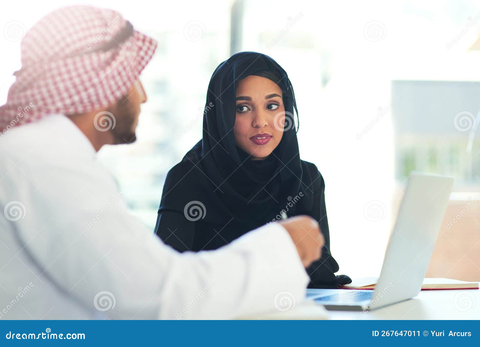 Hard Work and Teamwork before Anything Else. Two Muslim Coworkers Using ...