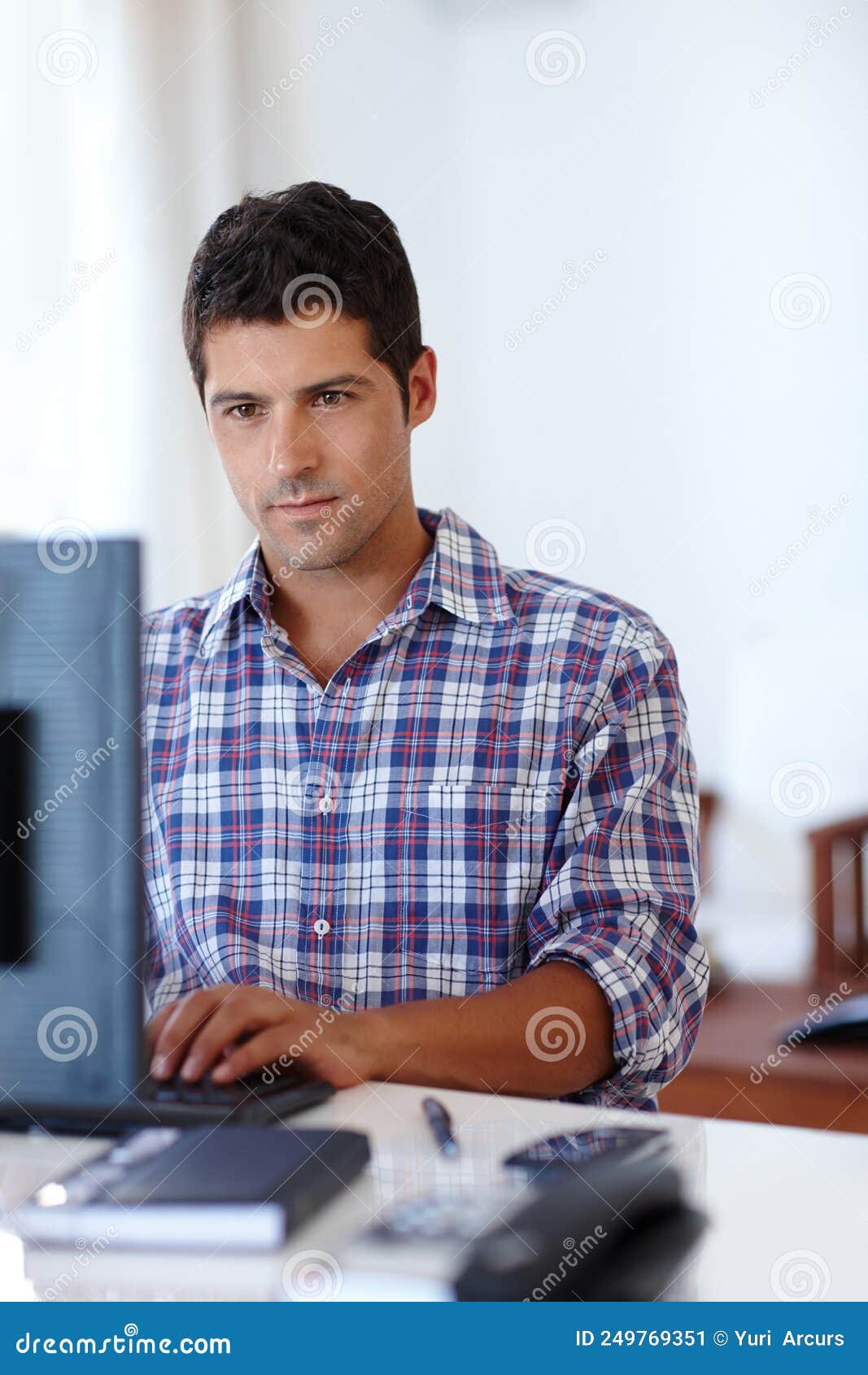 Hard at Work. a Young Man Concentrating while Sitting at a Desk in ...
