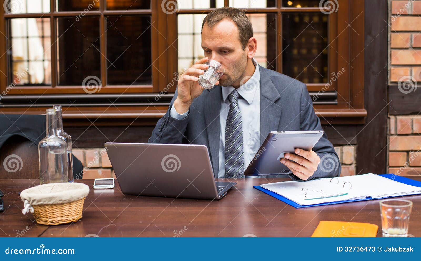 Hard Working Businessman in Restaurant with Laptop and Pad. he is ...