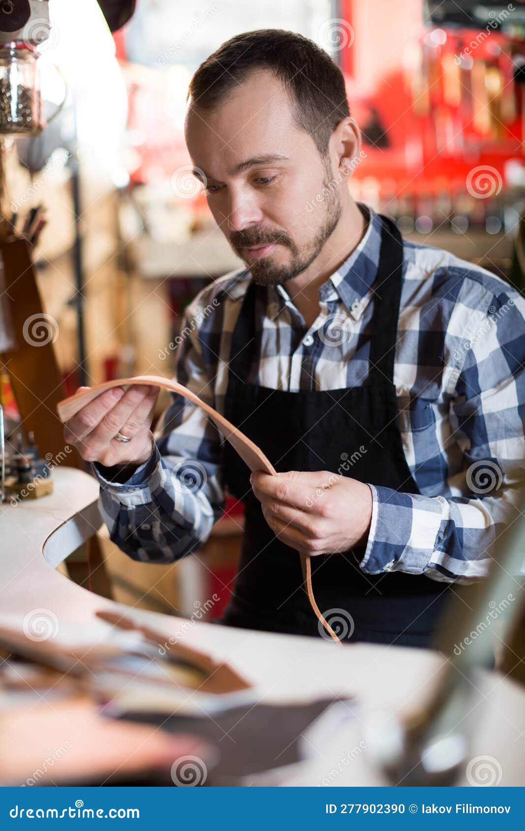 Hard-working Man Demonstrating His Workplace in Leather Workshop Stock ...