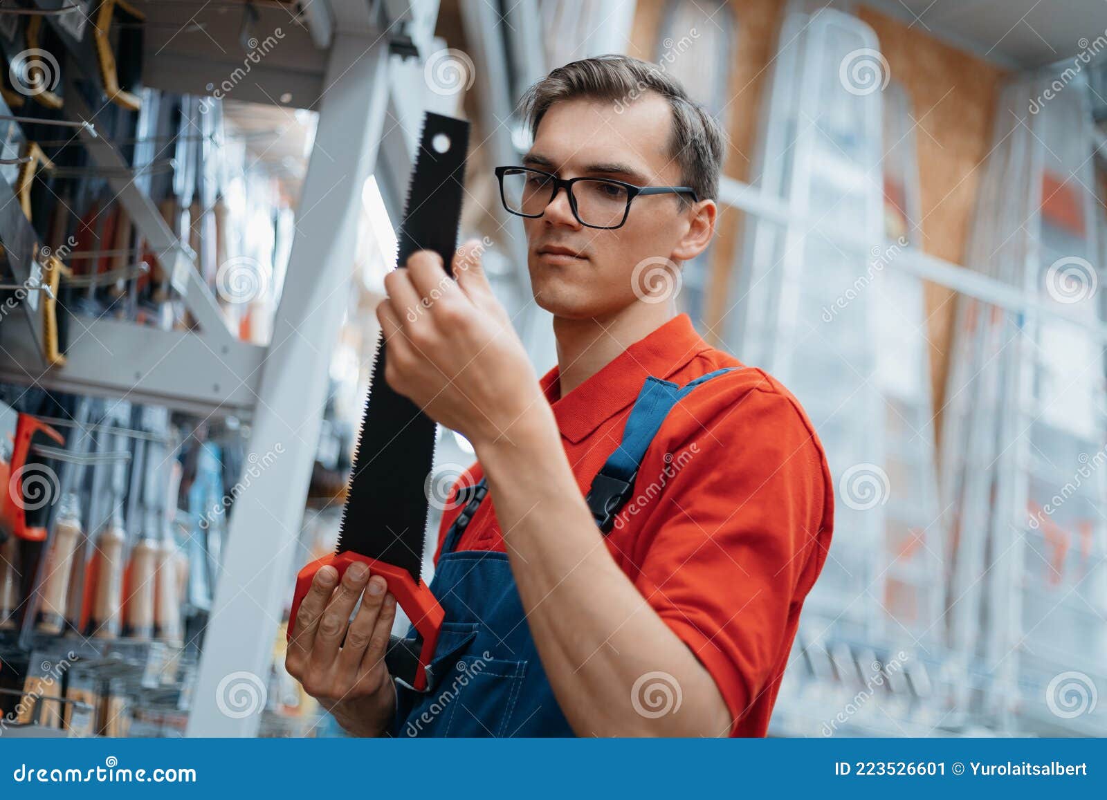 Hardware Store Clerk Checking the Markings on a Hand Hacksaw. Stock ...