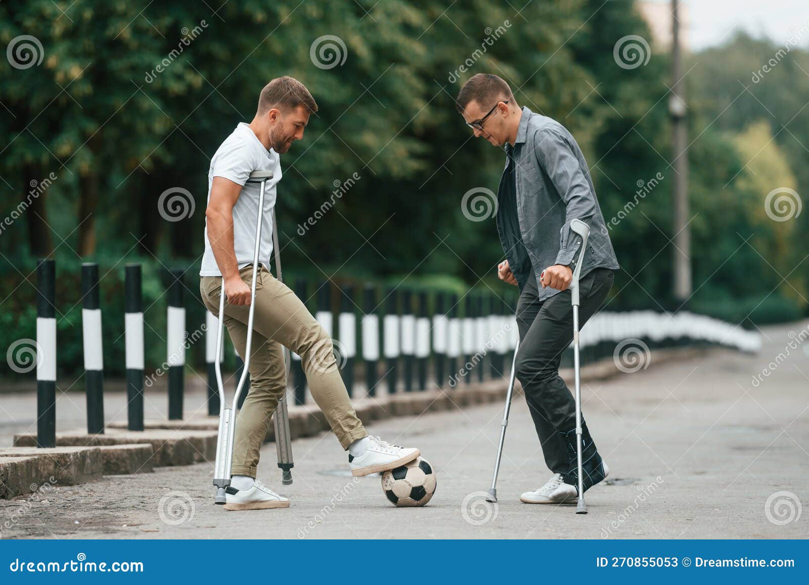 Having Fun, Playing Soccer. Two Men with Crutches is Outdoors on the ...