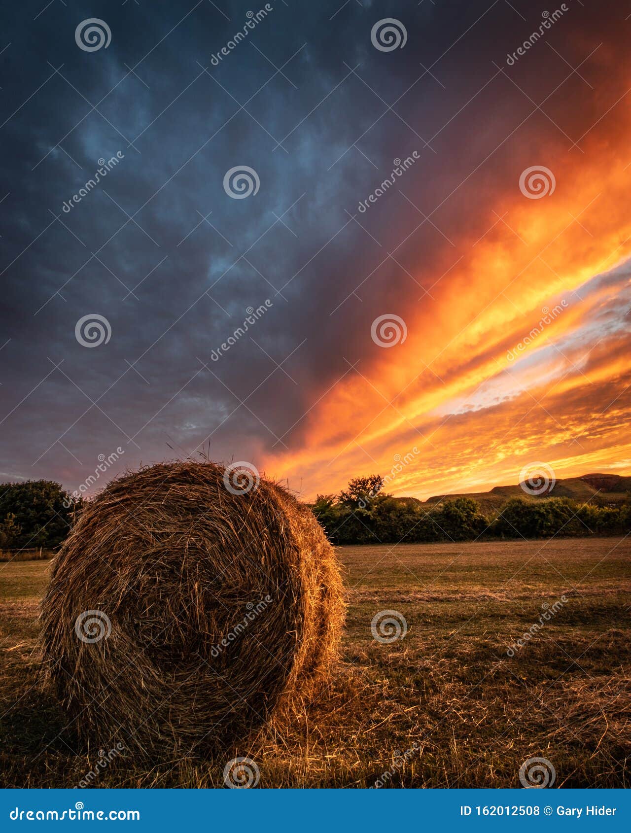 Hay Bales in a Field at Sunset Stock Photo - Image of brewing, sunsets ...
