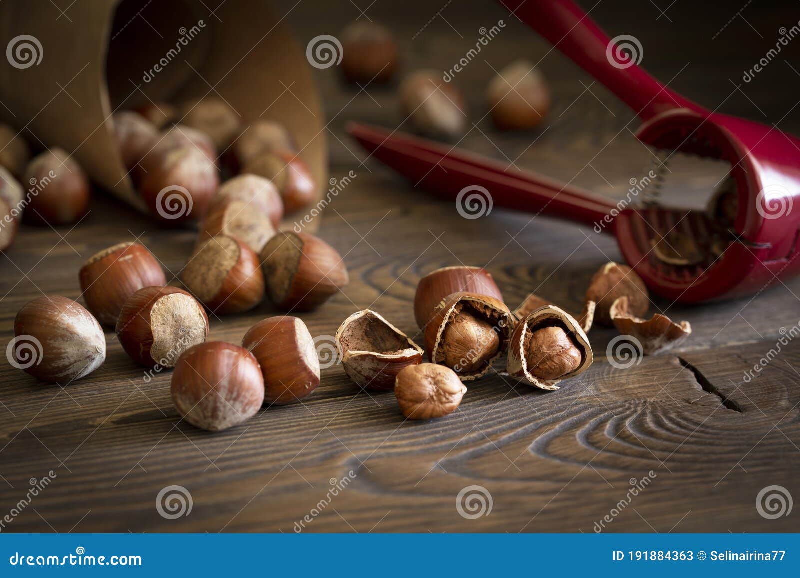 Hazelnuts with a Red Nutcracker on a Wooden Board. Nuts in Craft Paper ...