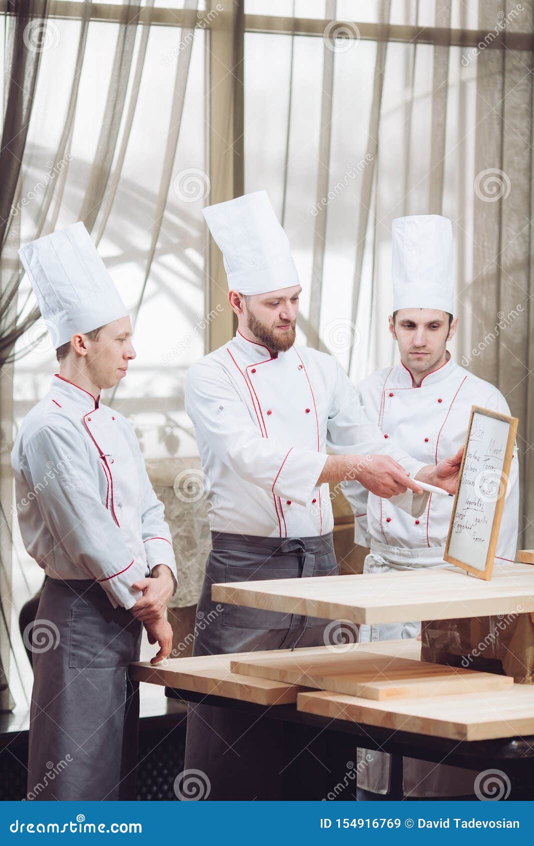 Head Chef and His Staff in Kitchen. Interacting To in Commercial ...