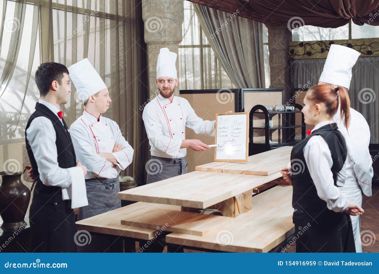 Head Chef and His Staff in Kitchen. Interacting To in Commercial ...