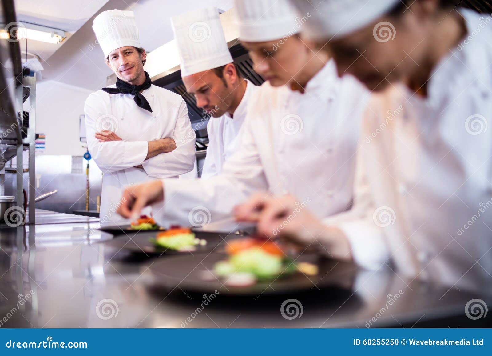 Head Chef Overlooking Other Chef Preparing Dish Stock Photo - Image of ...