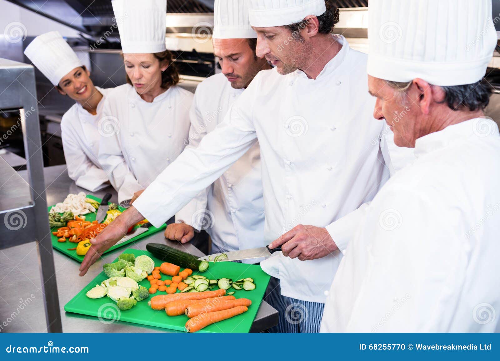 Head Chef Teaching His Colleagues How To Slice Vegetables Stock Photo ...