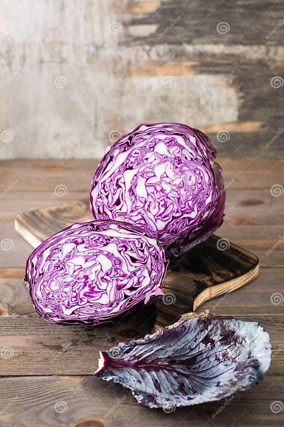 A Head of Red Cabbage Cut in Half on a Cutting Board on a Wooden Table ...