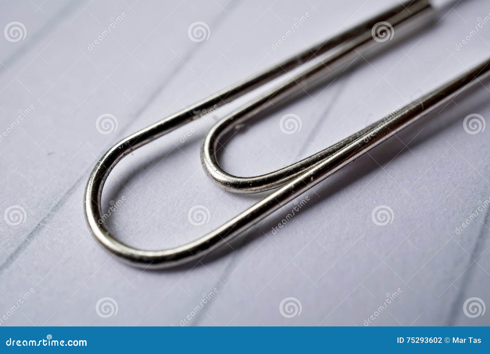 Heap Of Metal Paper Clips On White Lined Paper Notepad As A Symbol Of ...