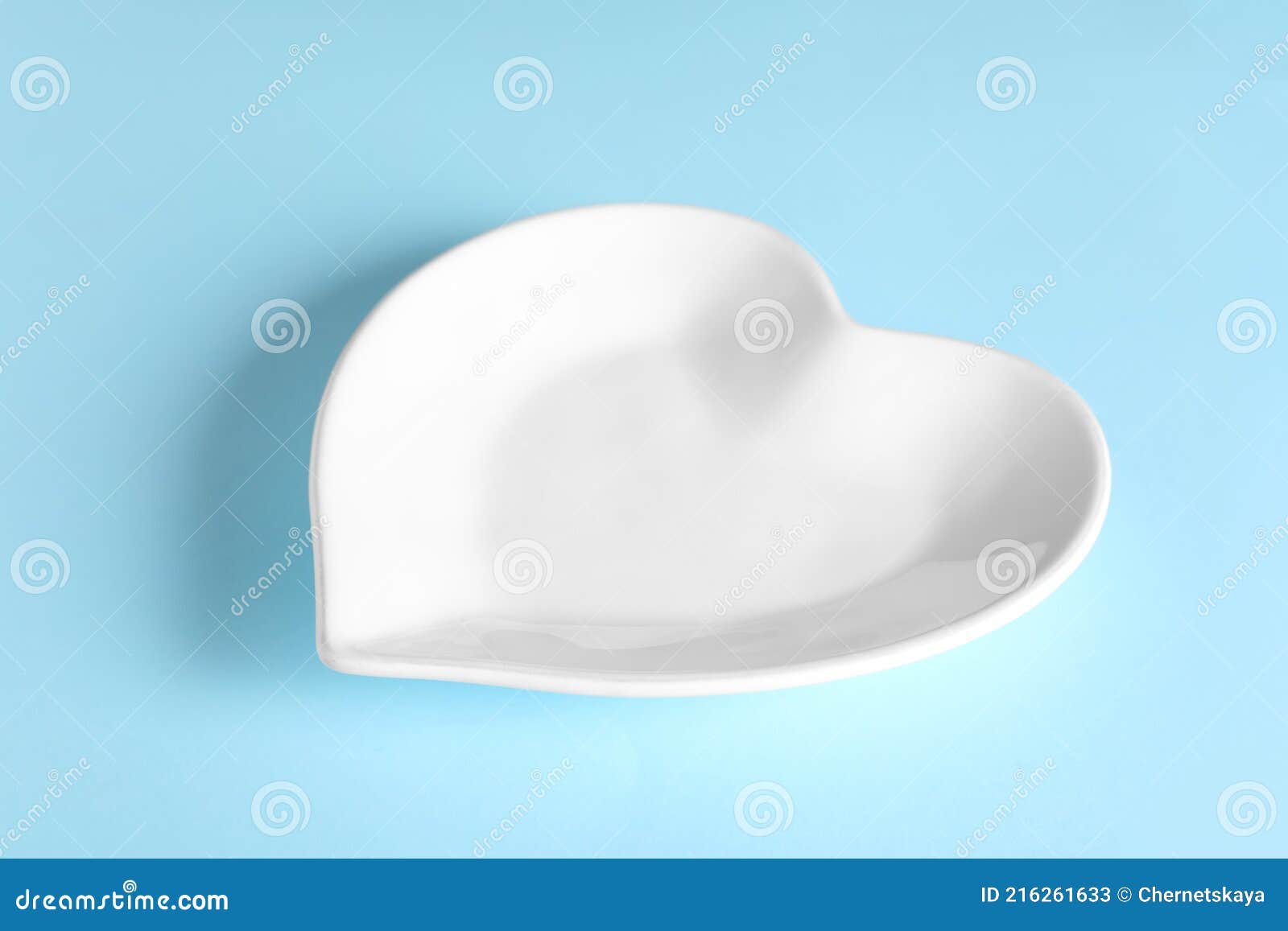 Heart Shaped Ceramic Plate on Light Blue Background, Closeup Stock ...