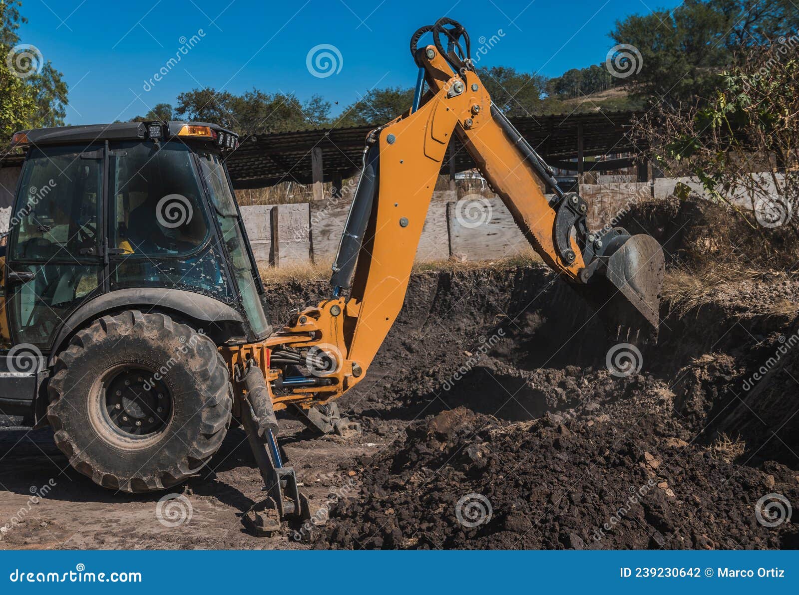 Heavy Machinery at Work, Backhoe Removing Dirt from a Material Bank ...