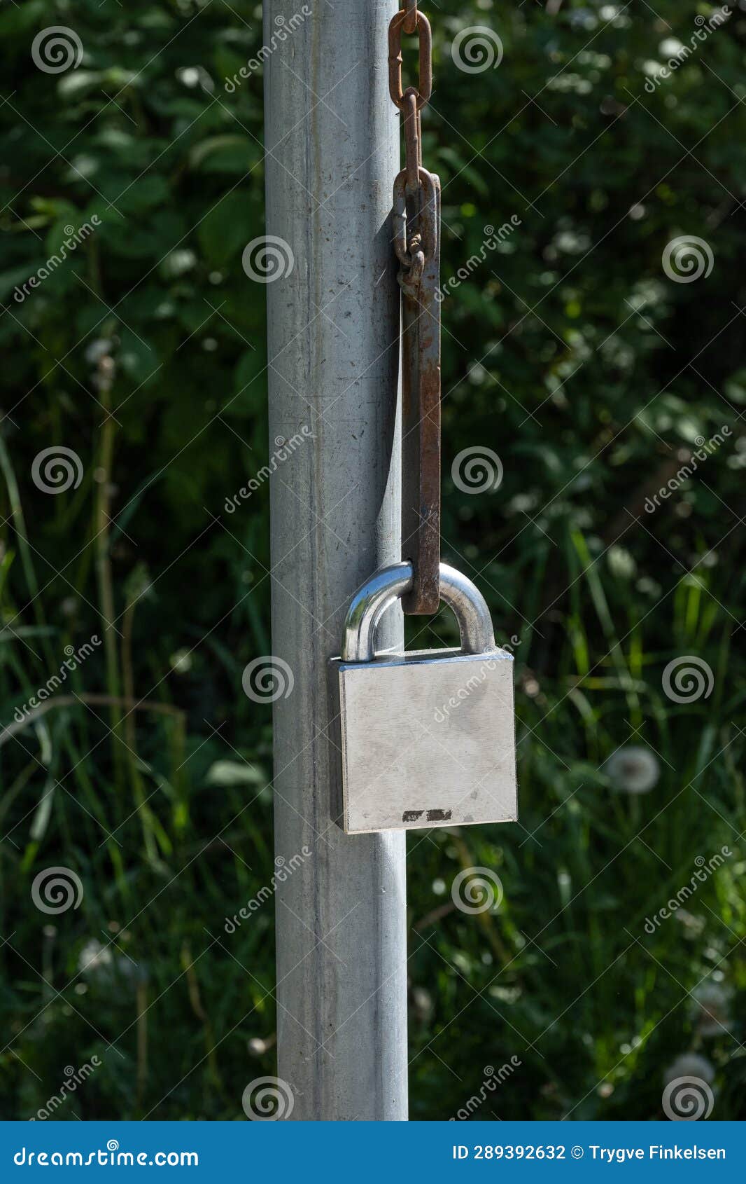 A Padlock Hanging On A Chain Of Rusty Gates In A Cemetery, A Closed ...