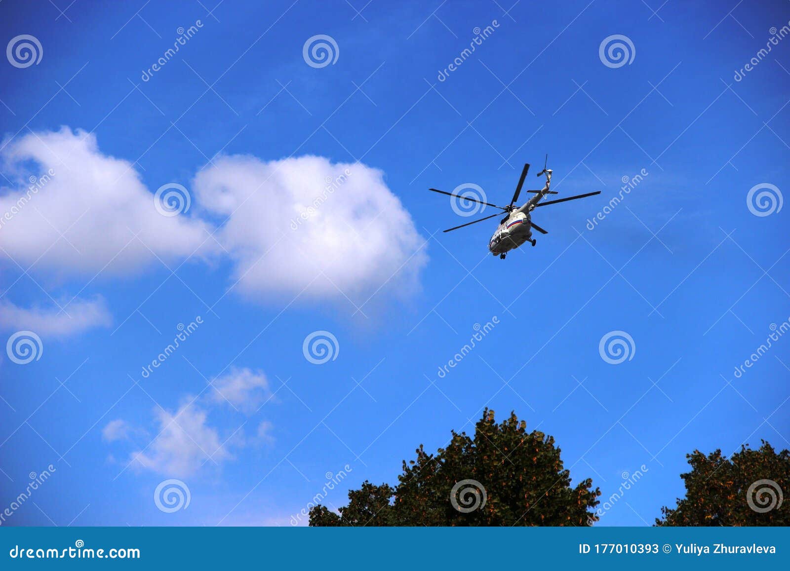 Helicopter Over the Trees in the Blue Sky with White Clouds Stock Image ...