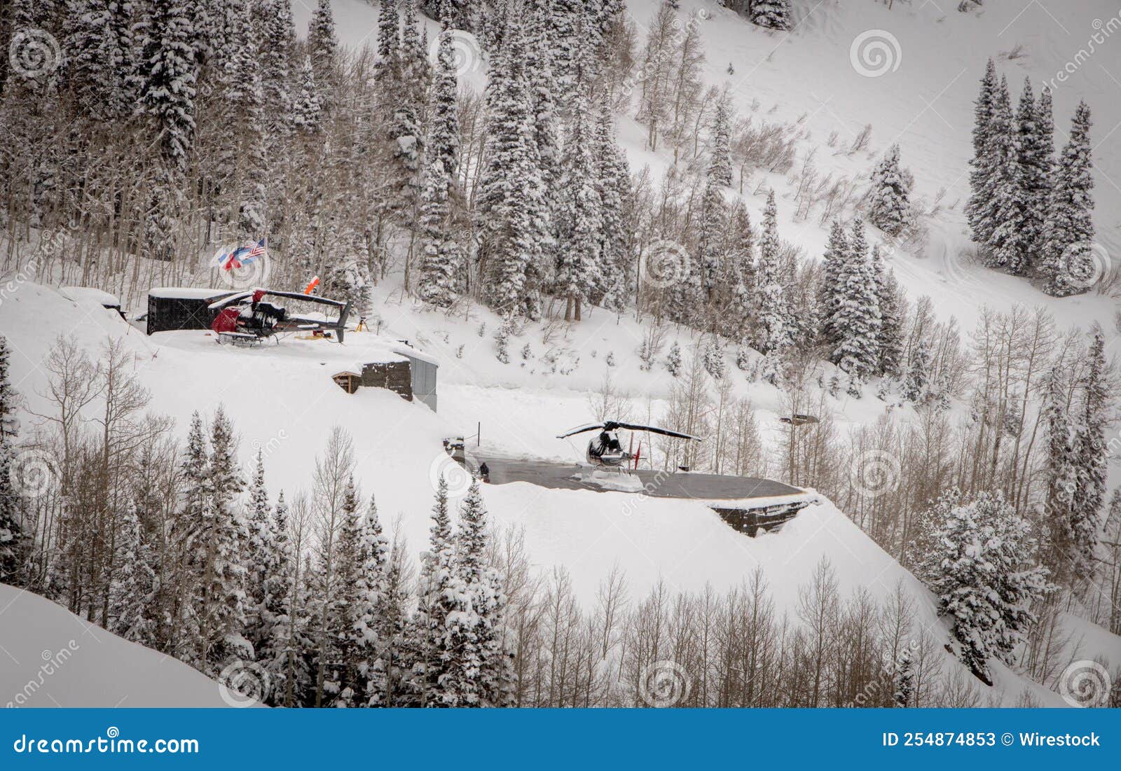 Helicopter Sits on a Landing Pad Surrounded by Snow in the Mountains ...