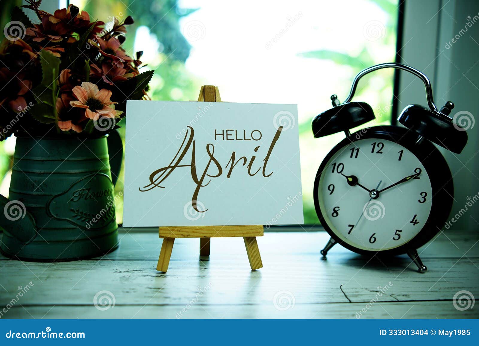 Hello April Text on Paper Card with Easel and Alarm Clock in the Window ...