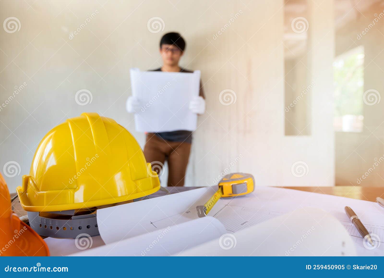 Helmet and Blueprint on Desk in Front of Engineer or Architect in ...