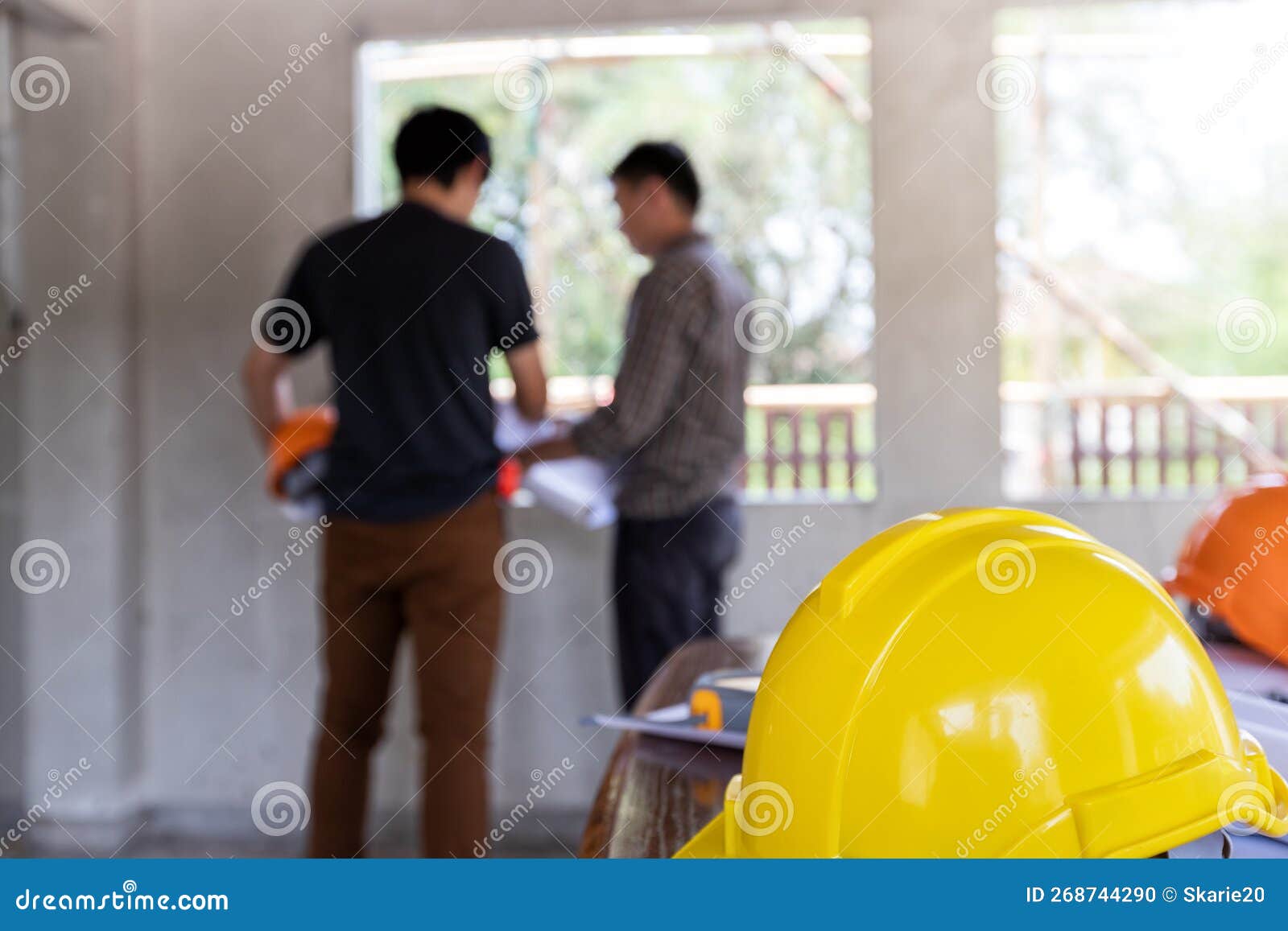 Helmets on Desk in Front of Engineer or Architect Discussing with ...