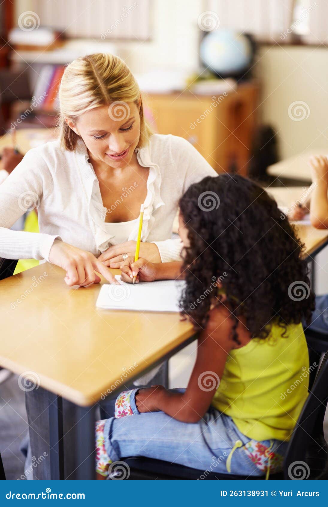 Helping Her with Her Homework. a Young Teacher Helping Children with ...