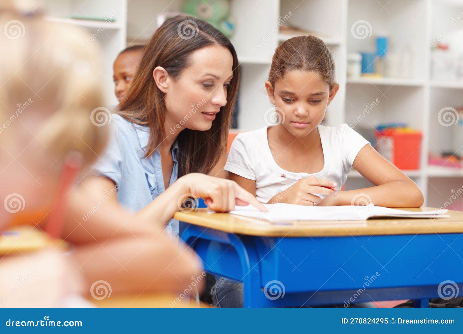 Helping Out Her Students. a Beautiful Young Teacher Helping Out a ...