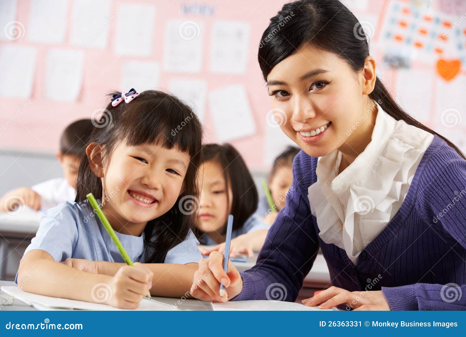 Helping Student Working At Desk In Chinese School Royalty-Free Stock ...